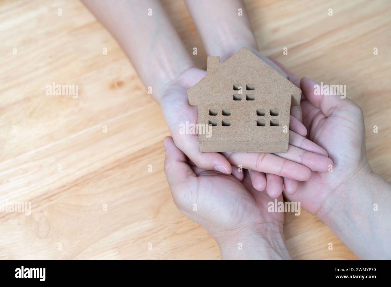 Human hands holding model house hi-res stock photography and images - Alamy