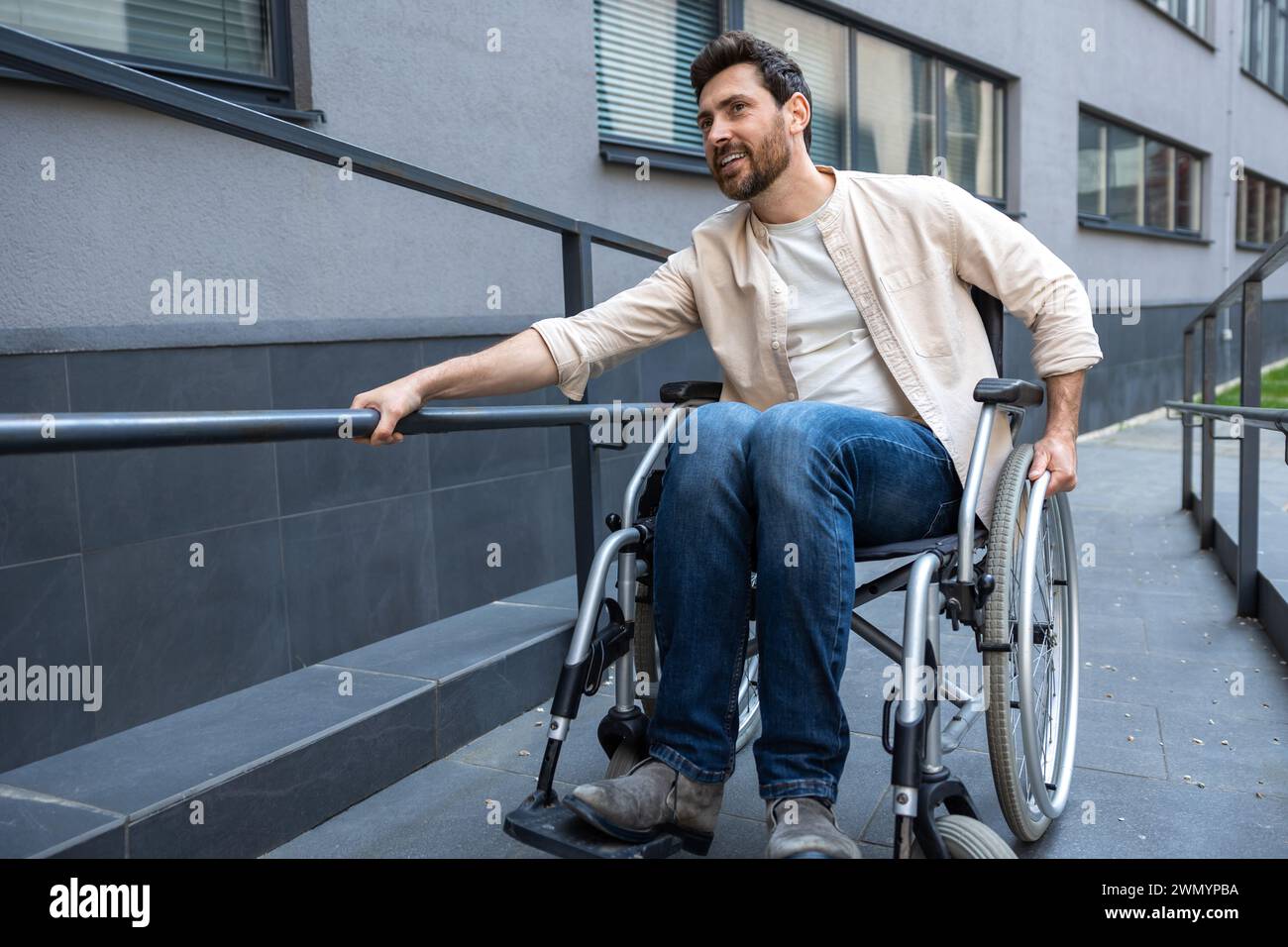 Disabled man on a wheelchair looking positive and smiling Stock Photo ...