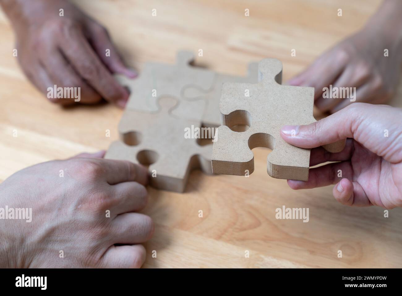 The hands that are helping each other assemble the jigsaw puzzle ...