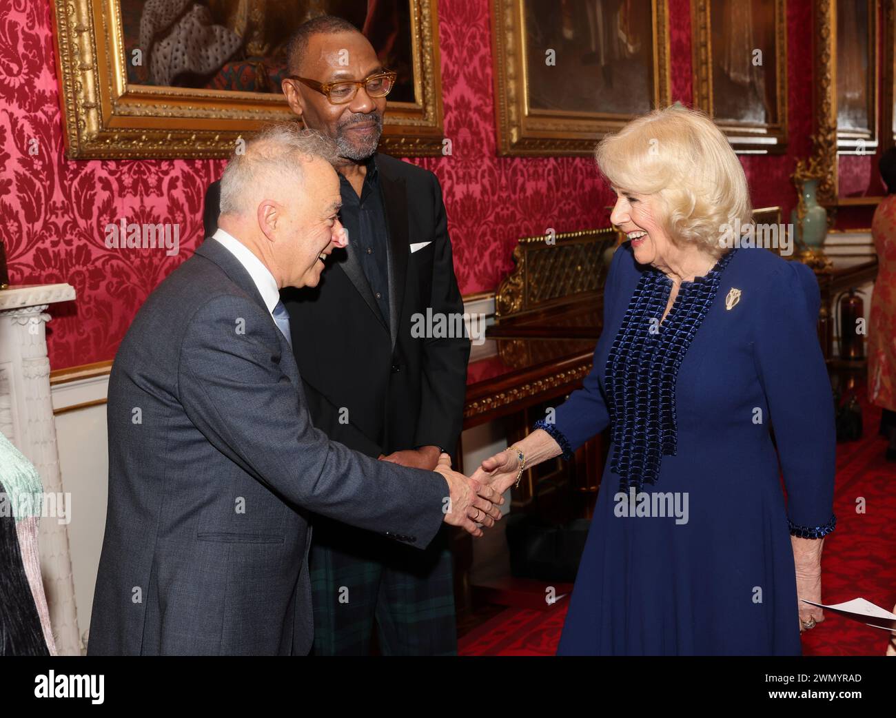 Queen Camilla shakes hands with Frank Cottrell-Boyce during a reception at Buckingham Palace in ...