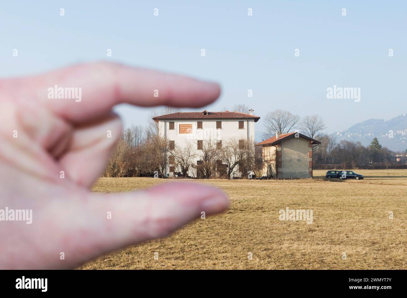Thumb and index fingers measuring a country house Stock Photo - Alamy