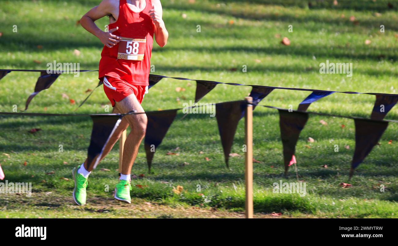 Side view of a High school boy running in a cross country 5K race on a ...