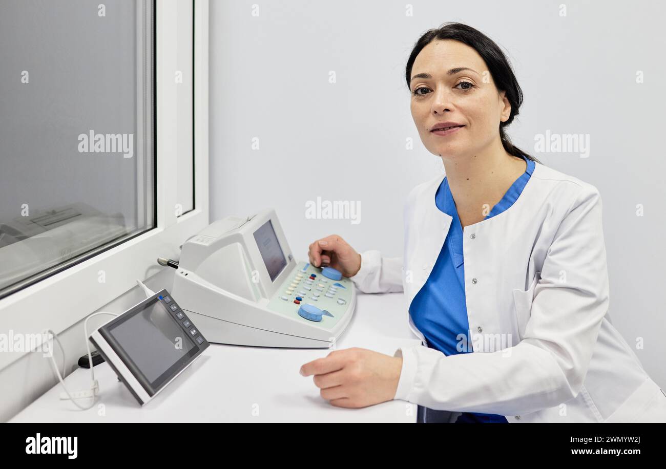 Hearing specialist sitting in her office of audiology department during ...