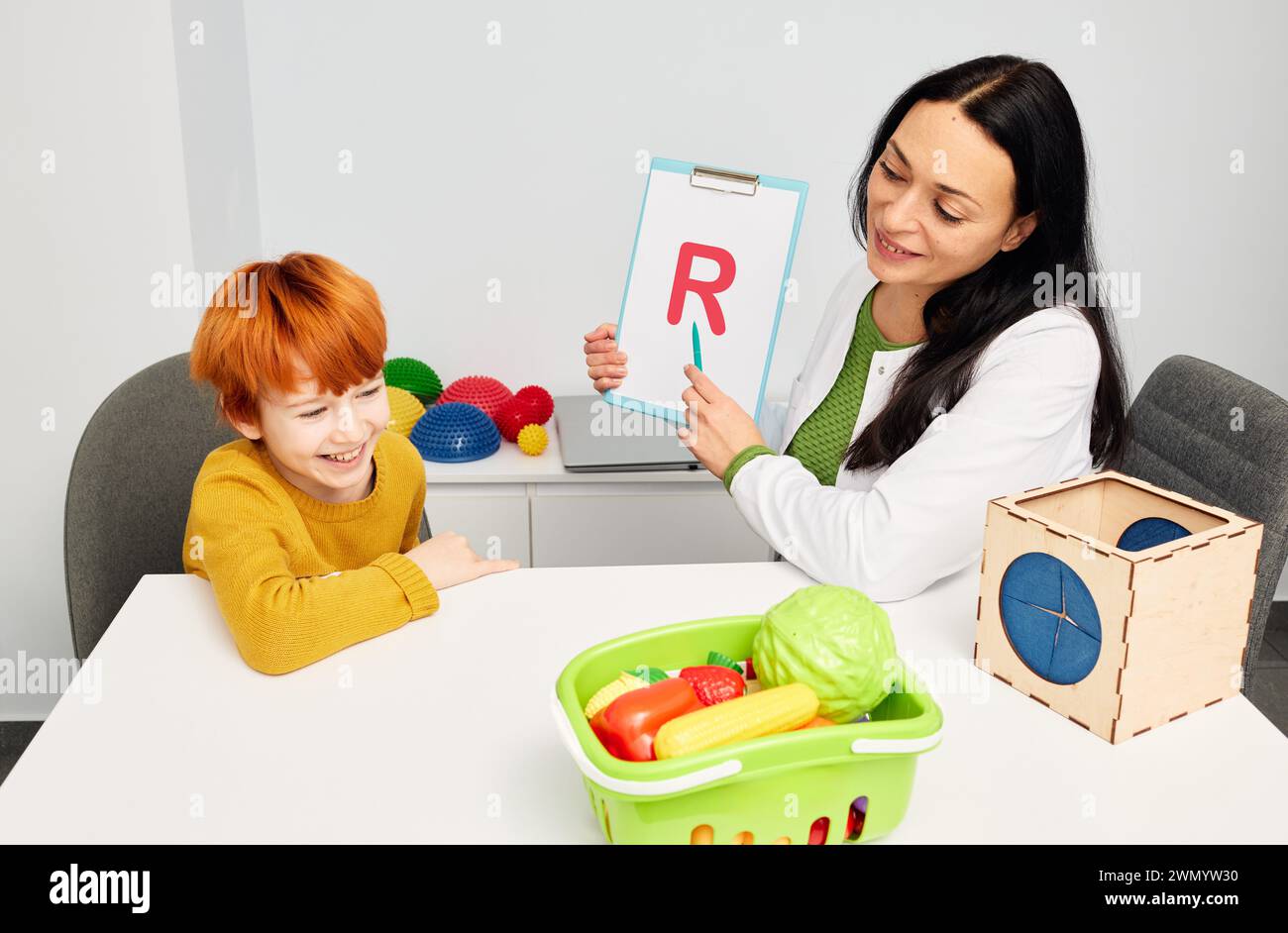 Professional speech and language therapist helping child patient with ...