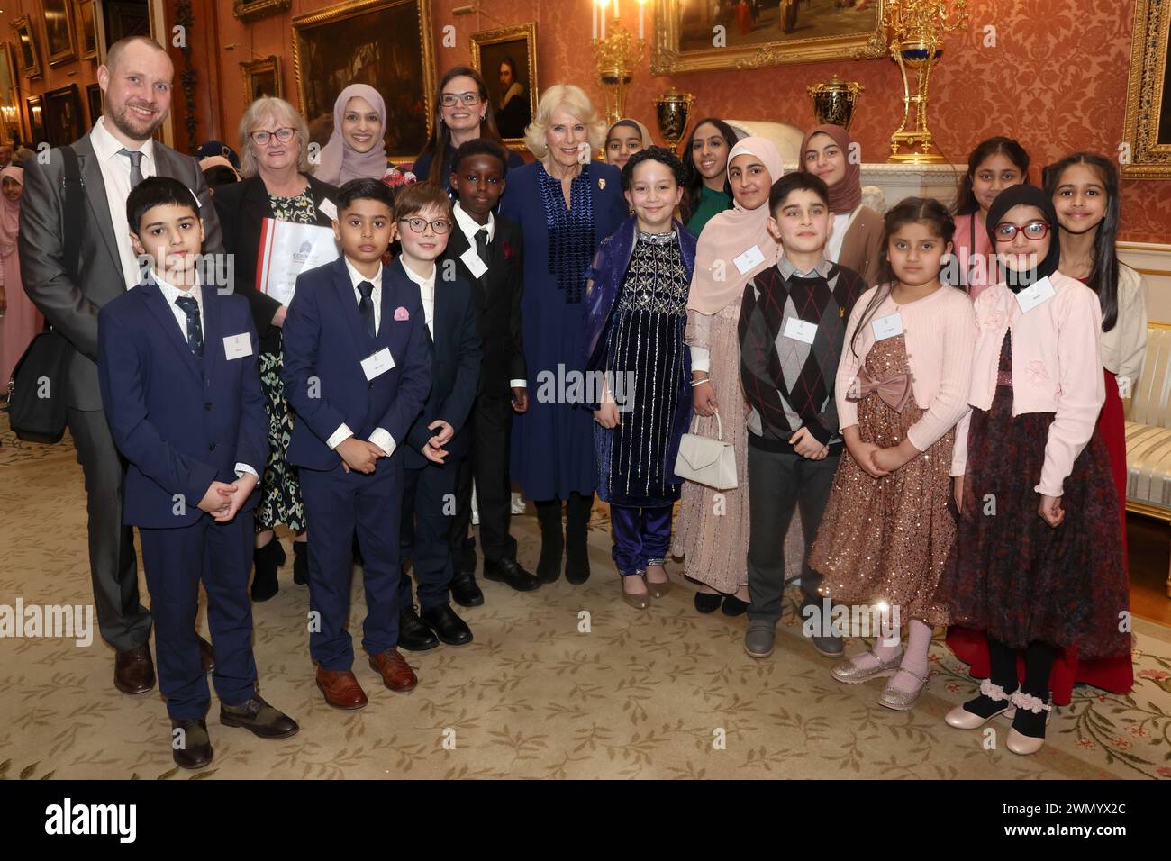 Queen Camilla poses with children during a reception at Buckingham ...