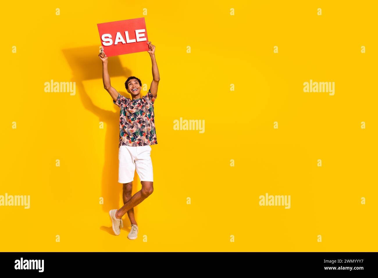 Full body length photo of young guy with red placard sale looking above ...
