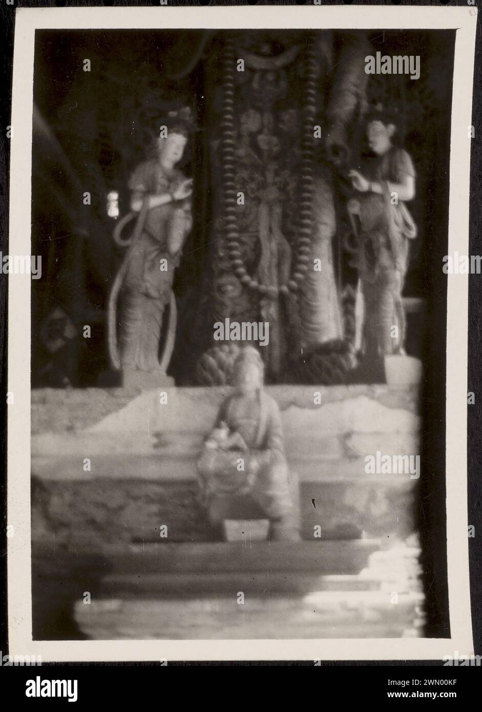 Three small statues next to a large statue. Three small statues next to ...