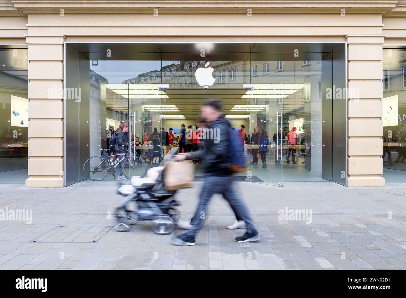 Shoppers are pictured walking past an apple store / shop in Bath ...