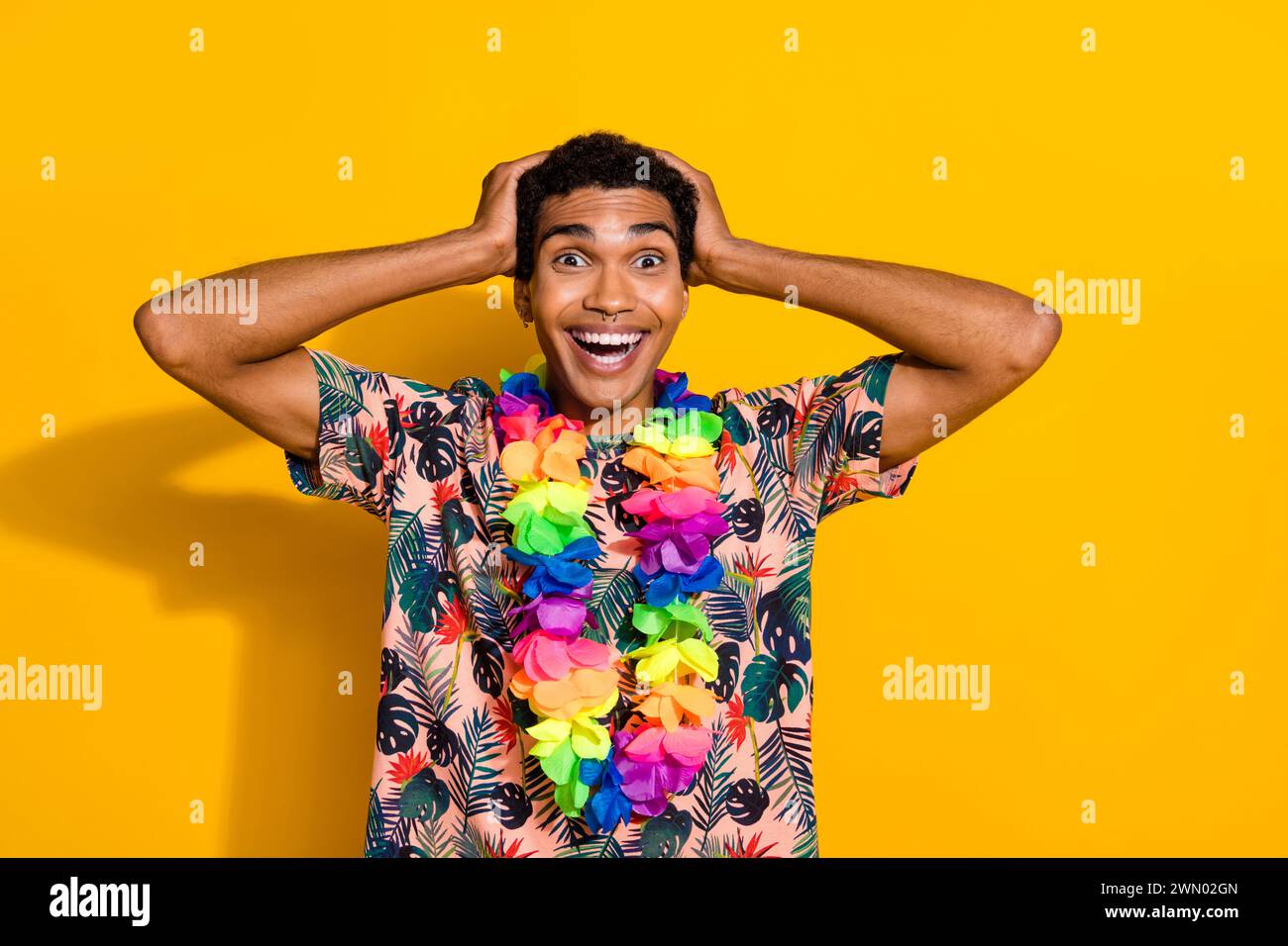 Photo of amazed young guy wearing hawaiian necklace he bought souvenir ...