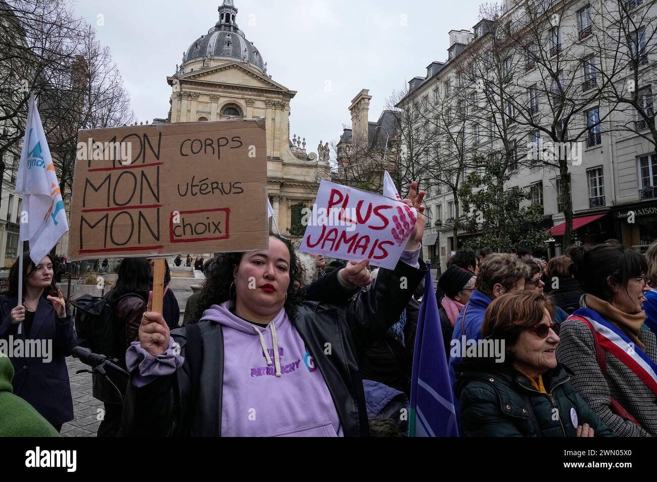 A pro-abortion rights activist holds signs read ' my body, my uterus ...