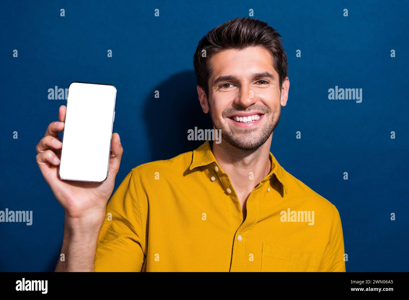 Photo portrait of attractive young man hold device show white screen ...