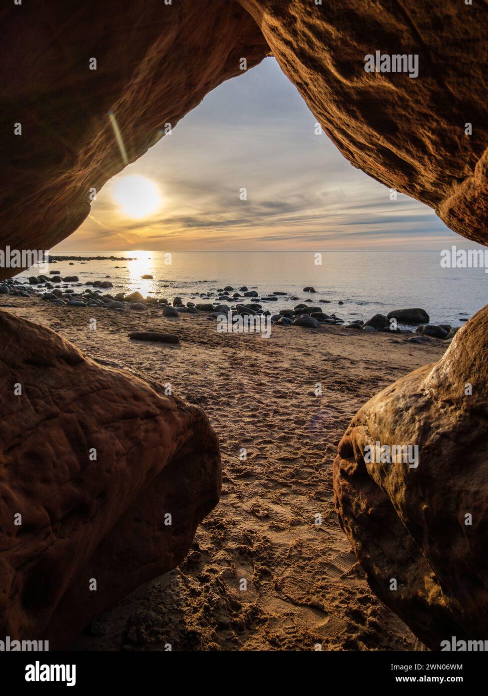 Peering out from the depths of Veczemju Klintis Cave, the silhouette of ...