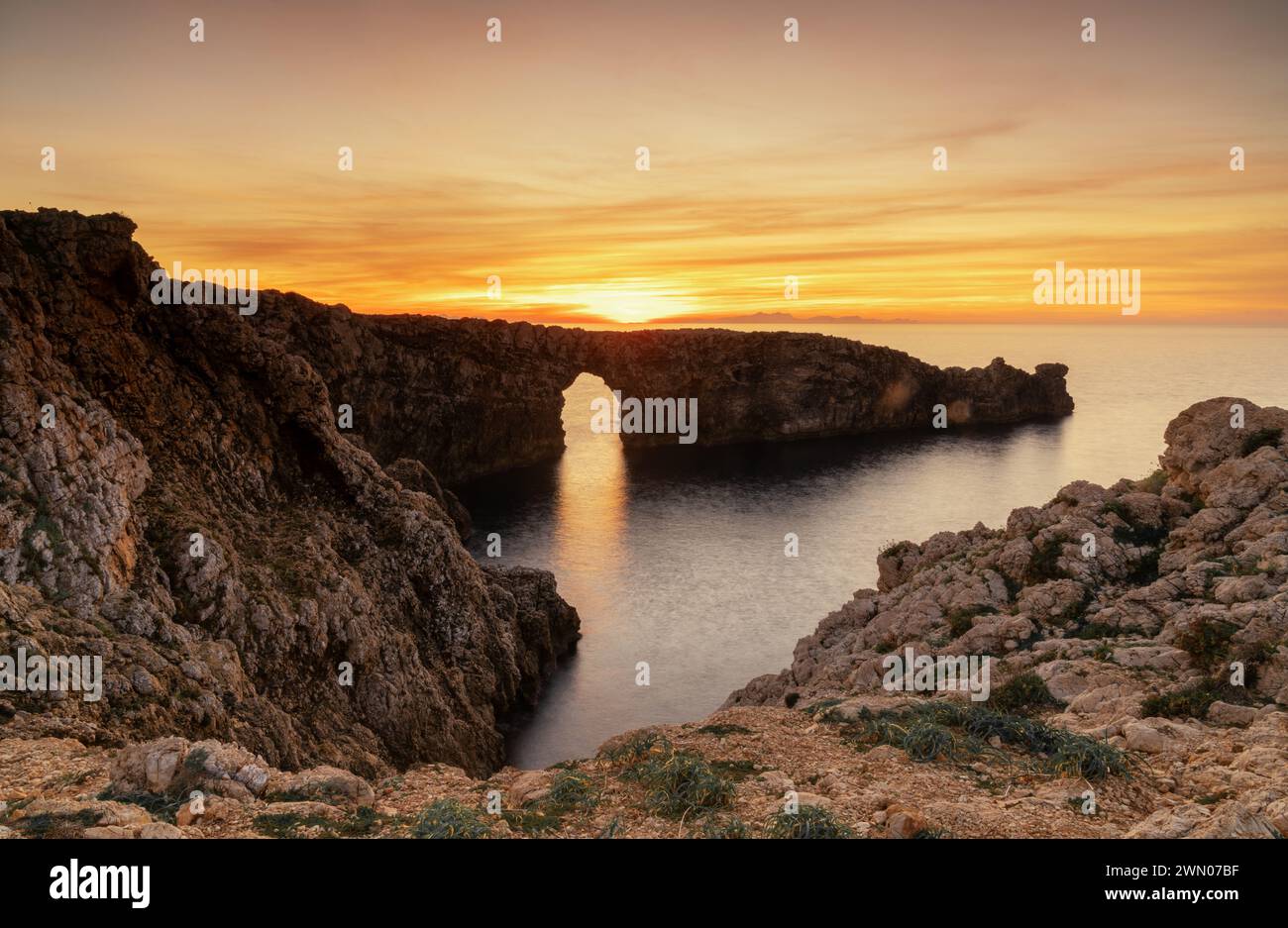 A view of the landmark stone arch of Pont d'en Gil on Menorca Island at ...