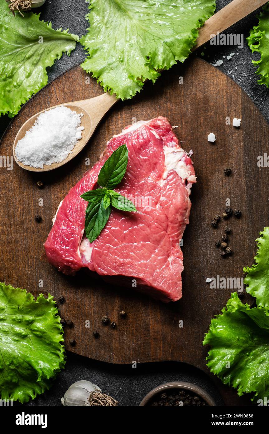 Raw beef steak meat on cutting board on rustic background with mint ...