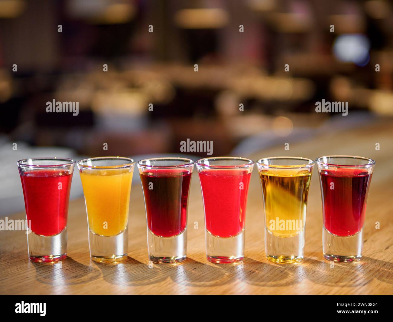 Set of colorful different bitters and liqueurs in shot glasses on bar ...