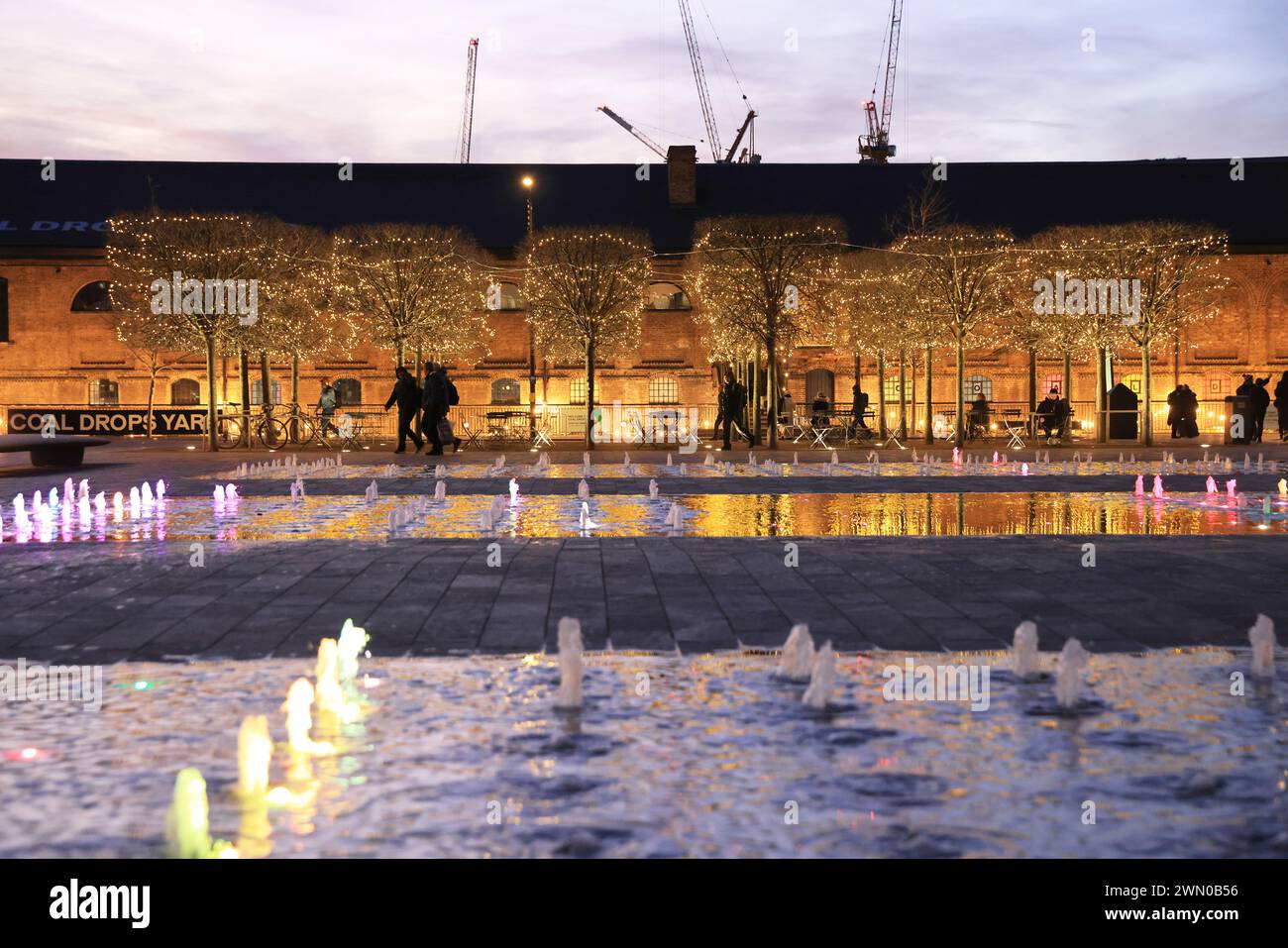The coloured fountains in Granary Square at twlight in winter, at Kings ...