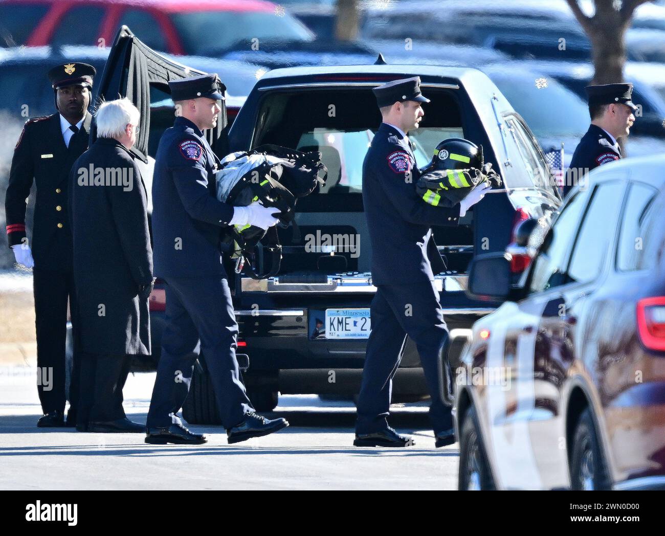 An honor guard carries the helmet and turnout gear of Burnsville ...
