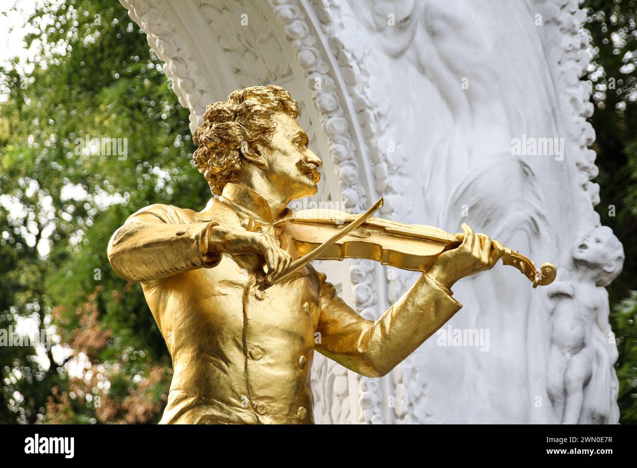 The golden statue of the great musician Johann Strauss in the city park ...