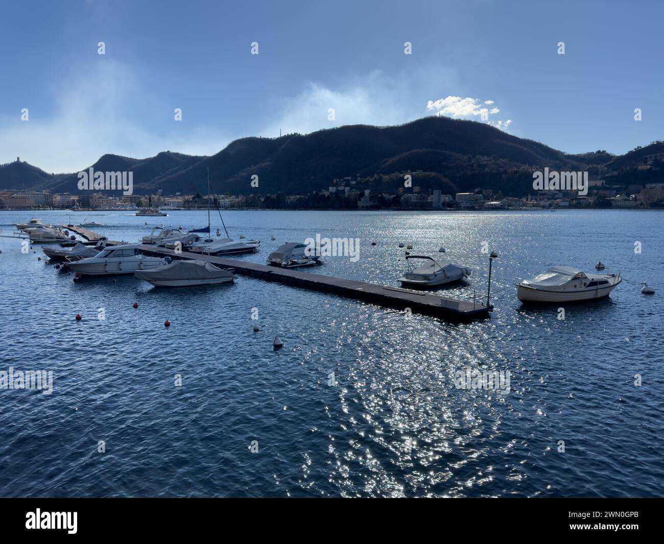 a beautiful view of the boats harboured in the Lake Como, CO, Lombardy ...