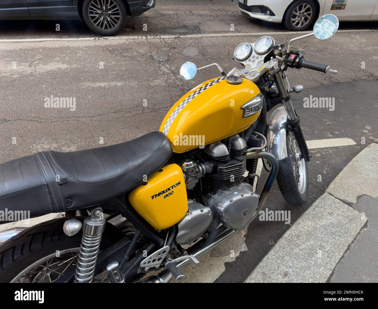 a beautiful vintage yellow scrambler "Triumph" motorcycle, parked in ...