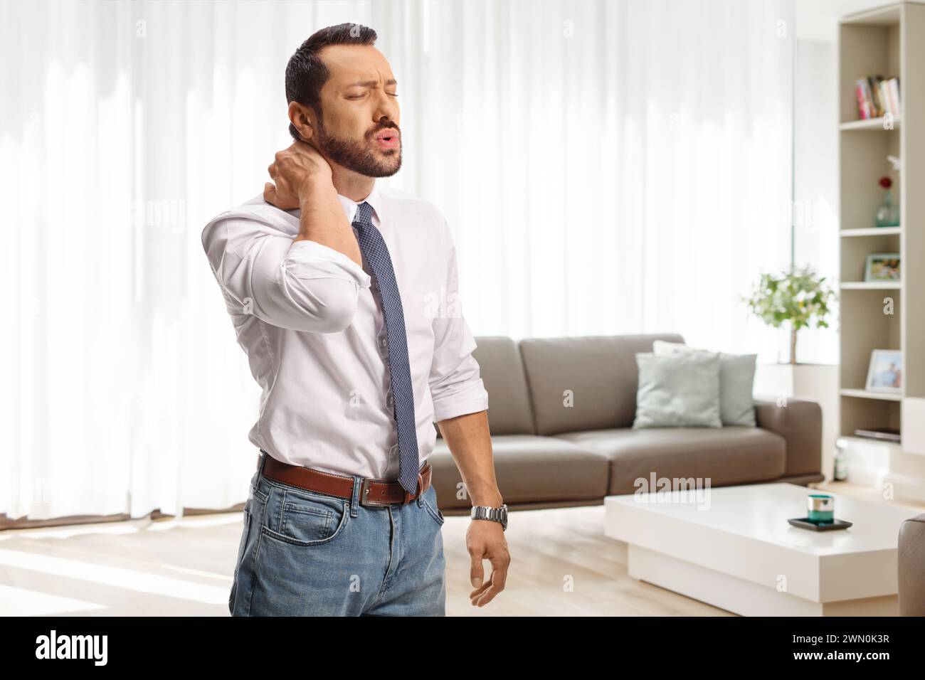 Man holding his stiff neck at home after a long day at work Stock Photo ...