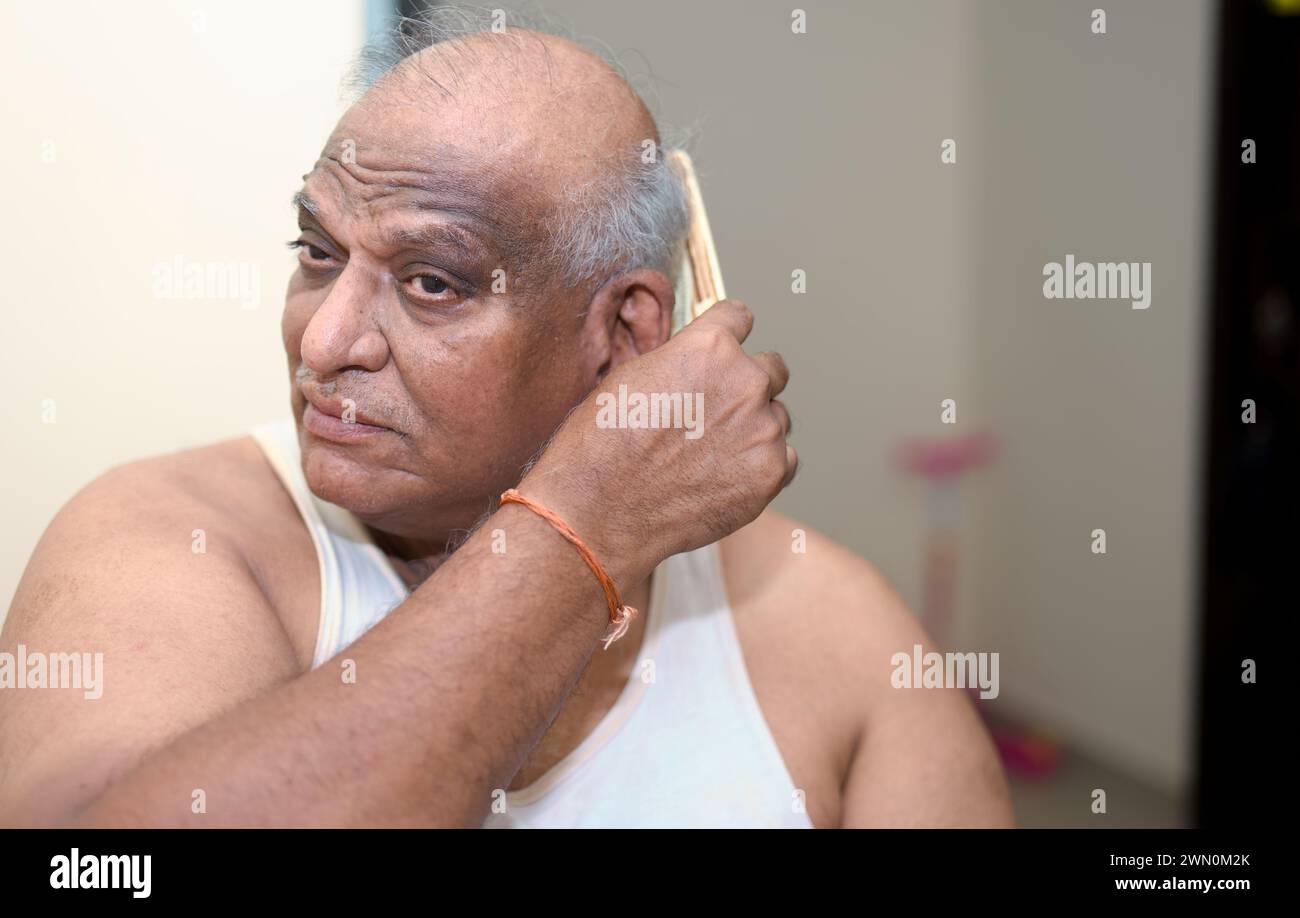 A close-up photo of a confident bald senior man using a well-worn ...