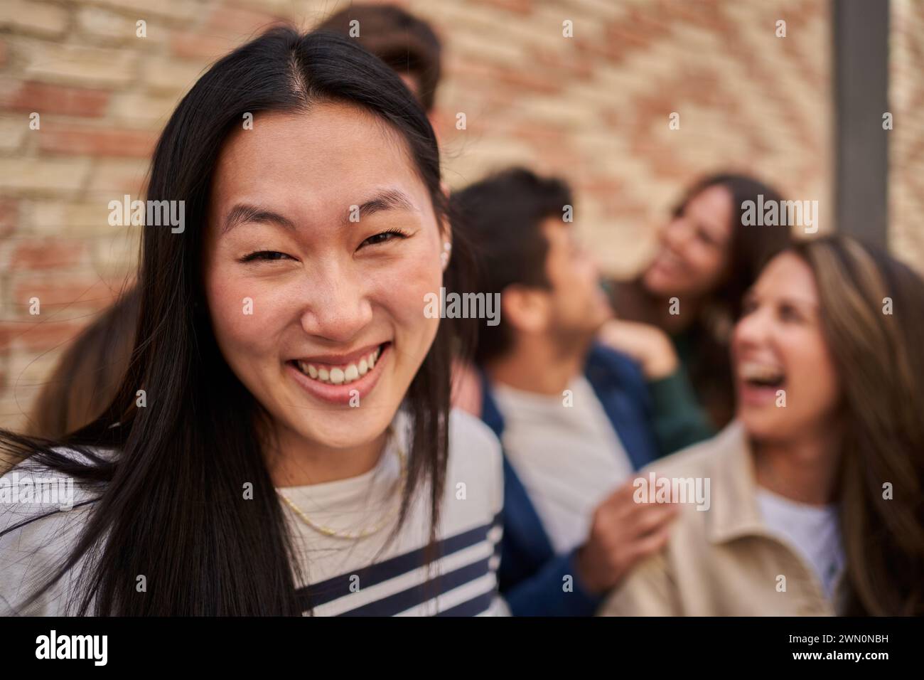 The woman smiles happily while sharing a fun moment with the group at ...