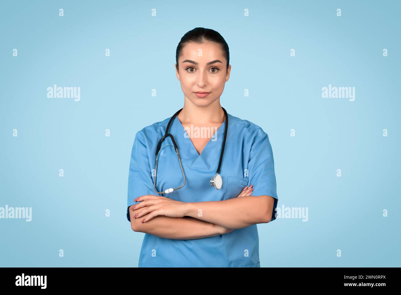 Serious female nurse with crossed arms in scrubs Stock Photo - Alamy