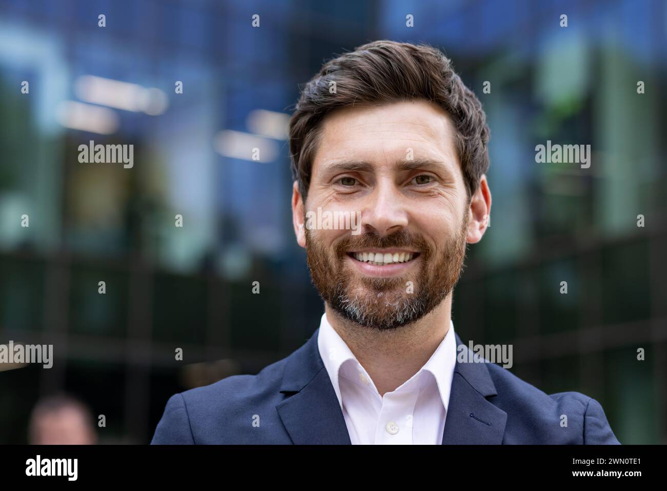 Portrait of a smiling businessman in a contemporary urban setting ...