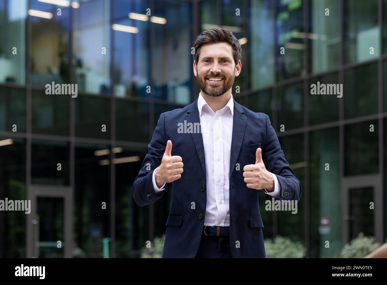 Smiling corporate professional in a suit outside an office building ...