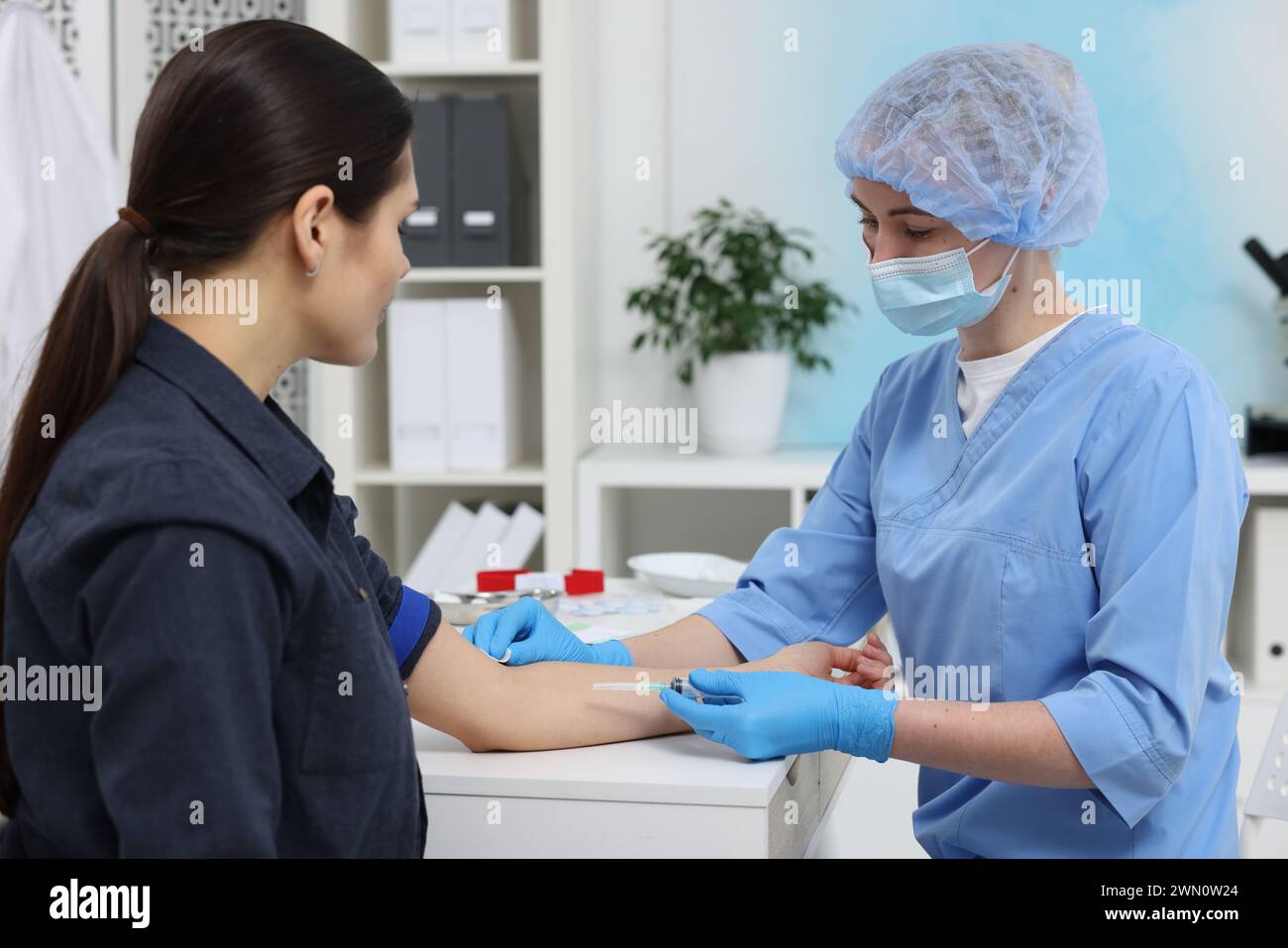 Laboratory testing. Doctor taking blood sample from patient at white ...
