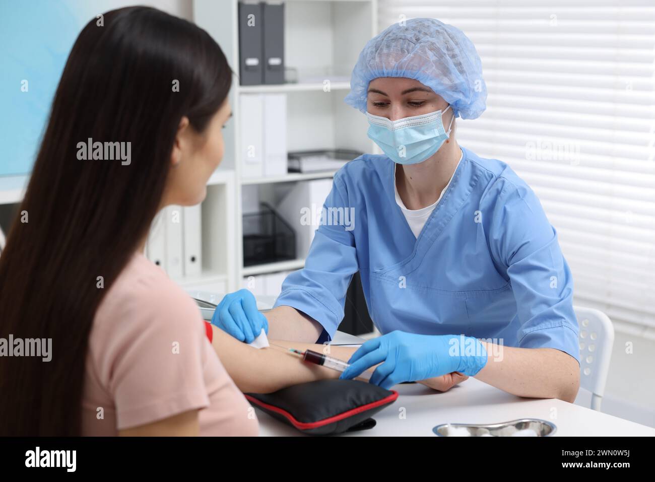 Laboratory testing. Doctor taking blood sample from patient at white ...