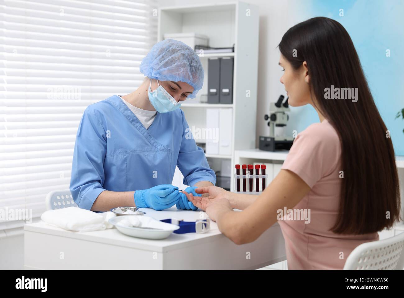 Laboratory testing. Doctor taking blood sample from patient at white ...
