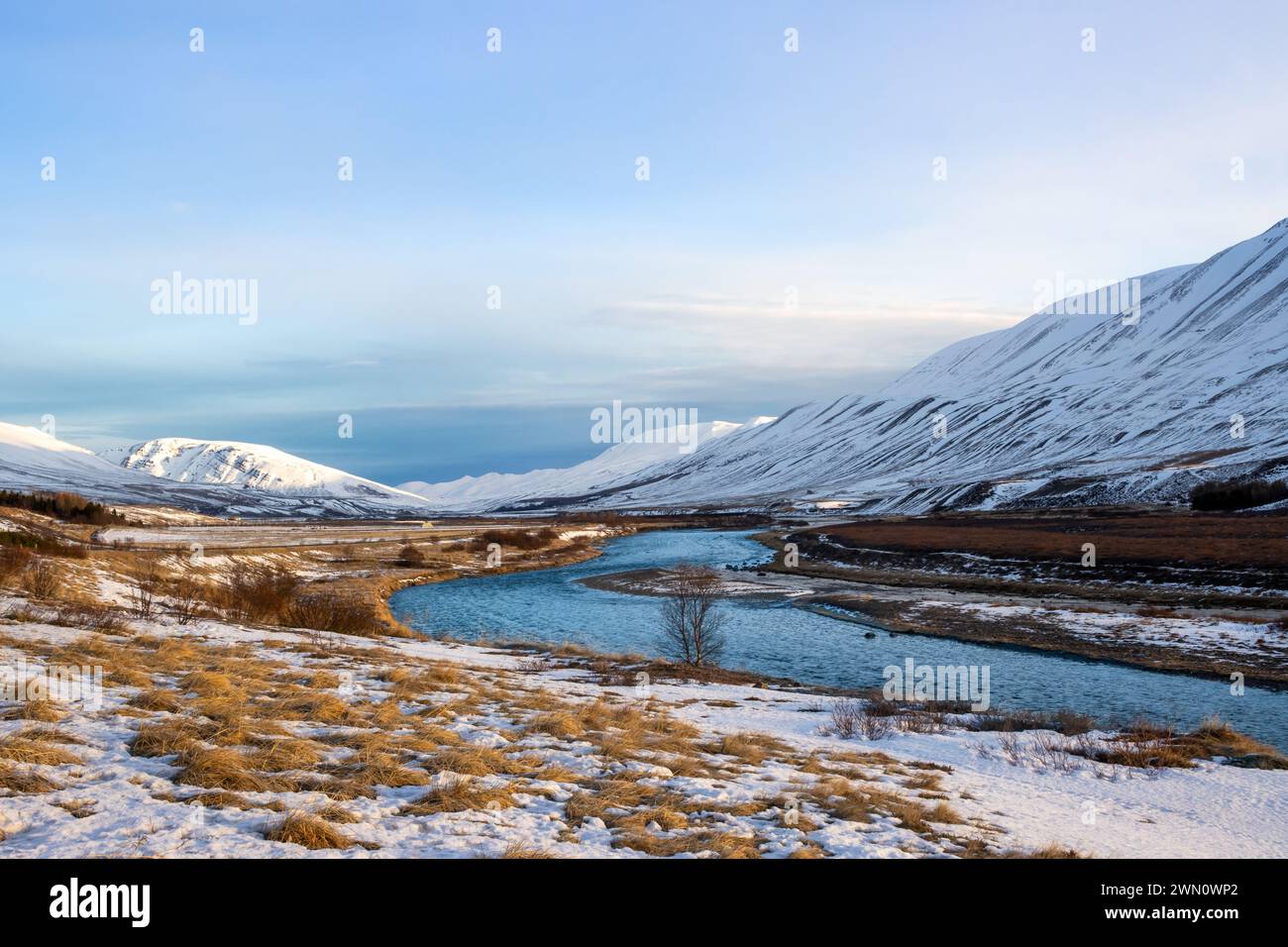 Valley surrounded by mountains. River flowing among the pastures ...
