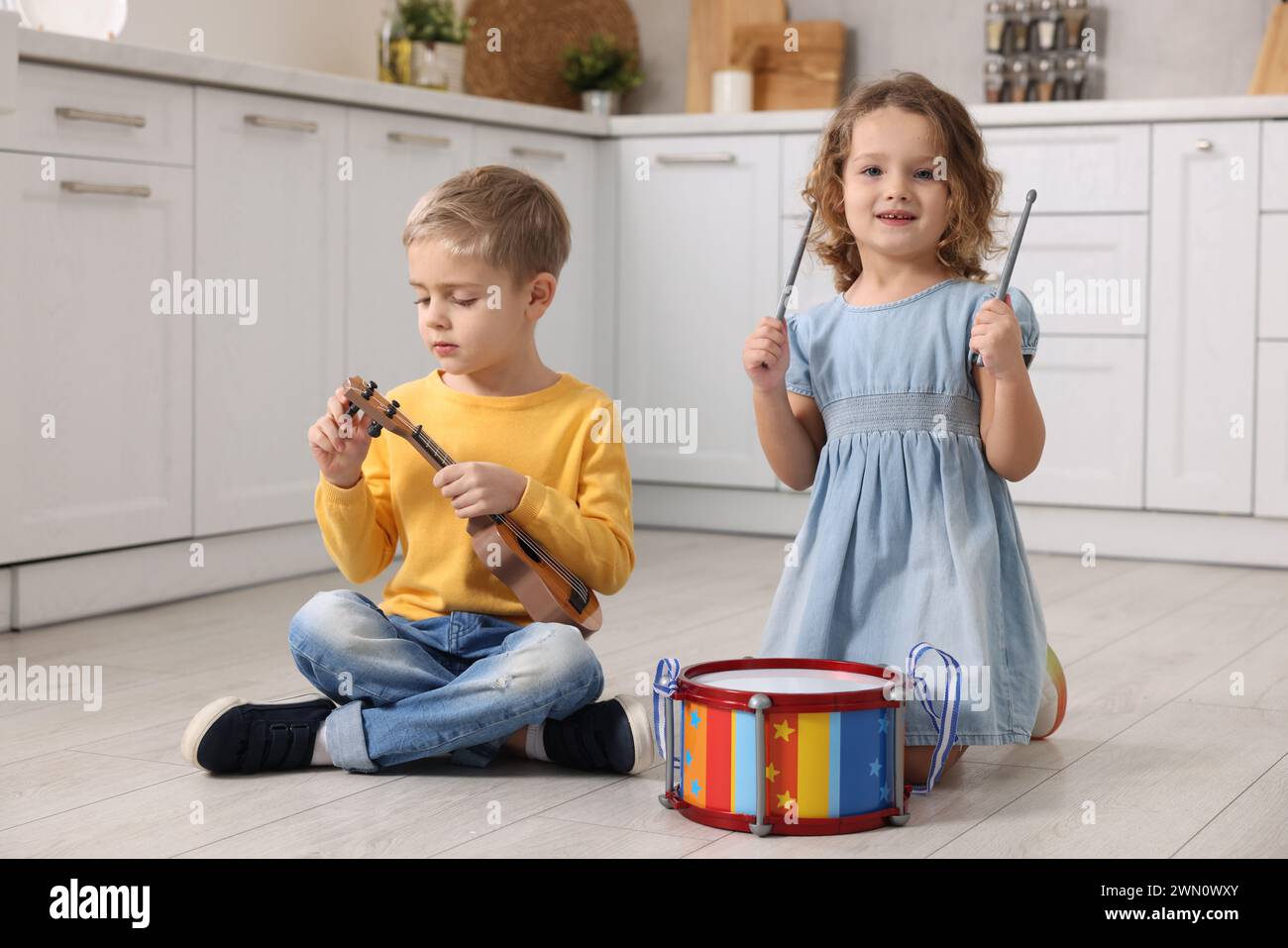 Little children playing toy musical instruments in kitchen Stock Photo ...