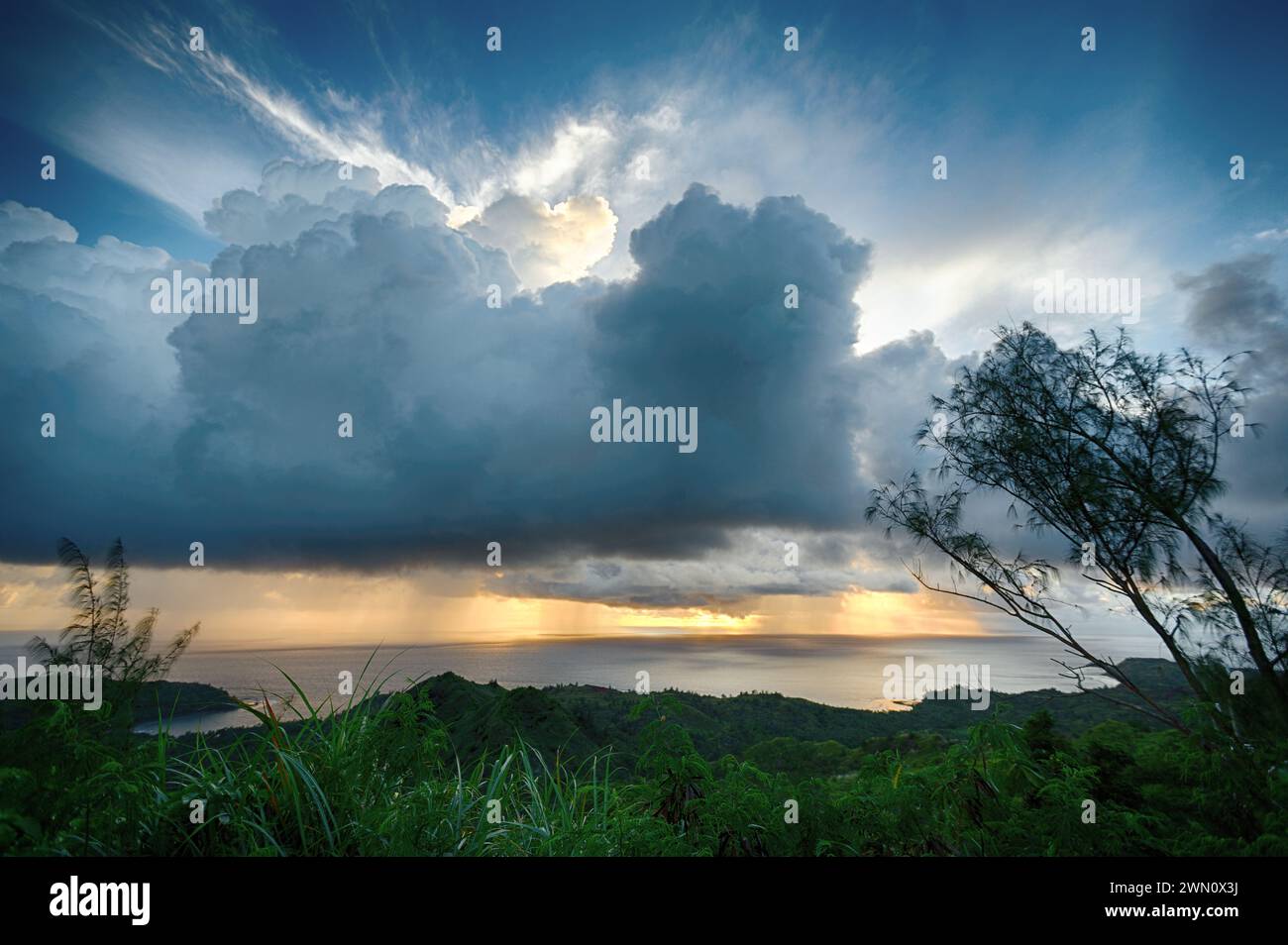 A large thundercloud blocks the sun over Cetti Bay and Sella Bay off ...