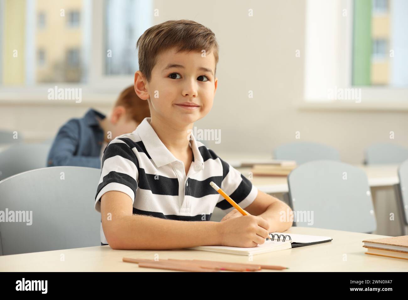 Portrait of cute little boy studying in classroom at school Stock Photo ...
