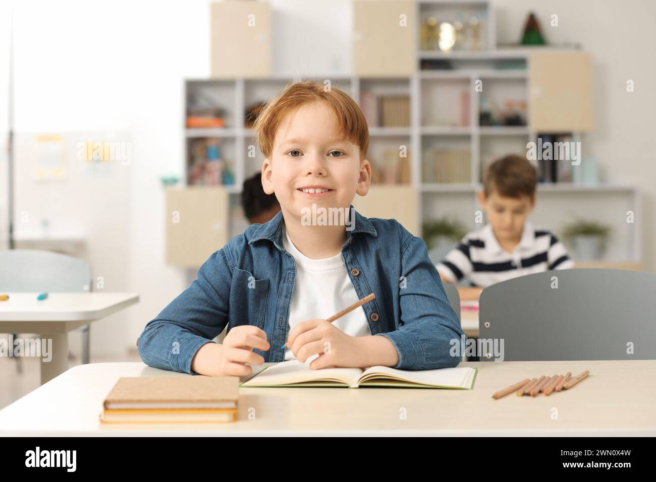 Portrait of smiling little boy studying in classroom at school Stock ...