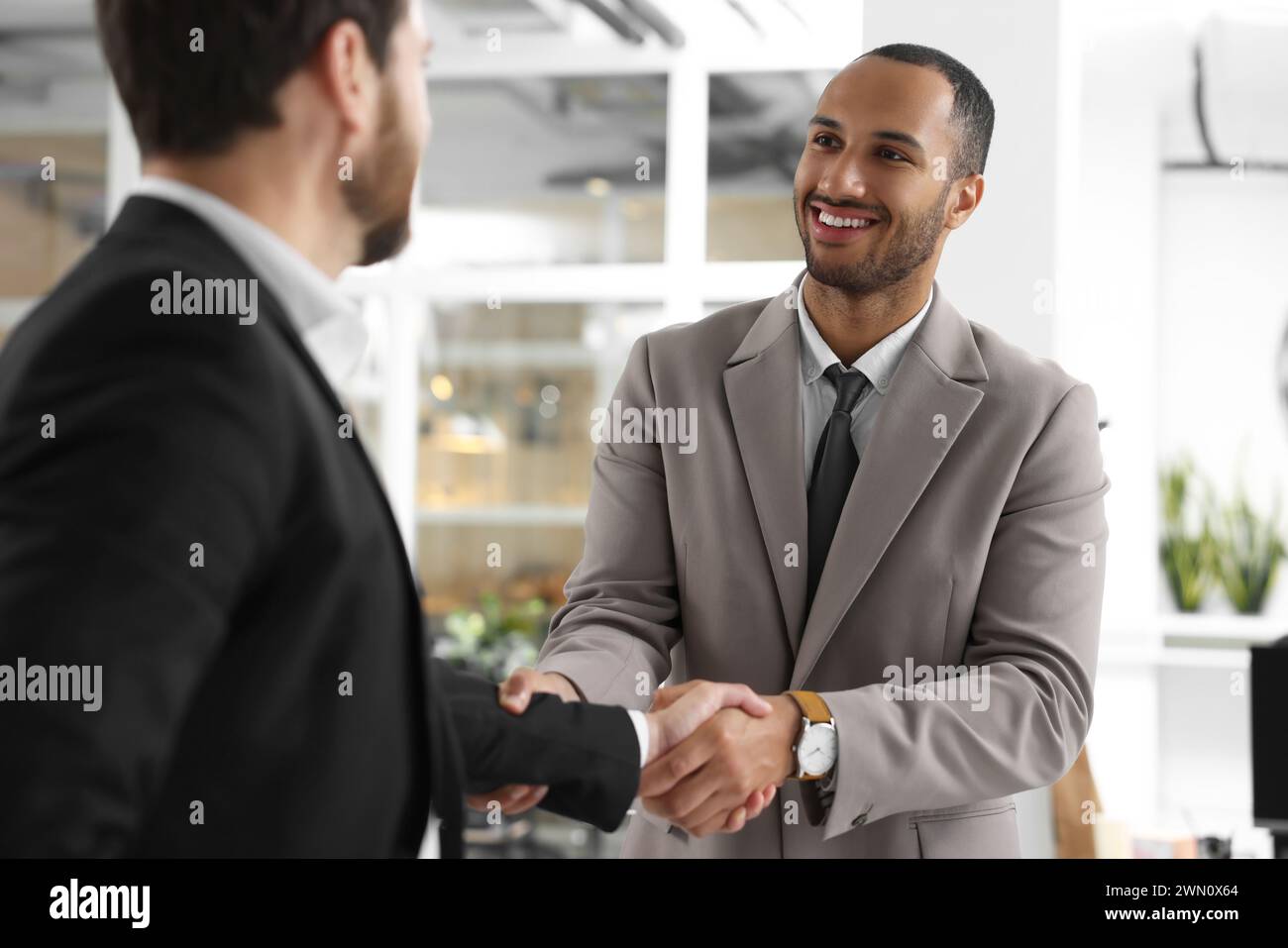 Lawyer shaking hands with client in office Stock Photo - Alamy