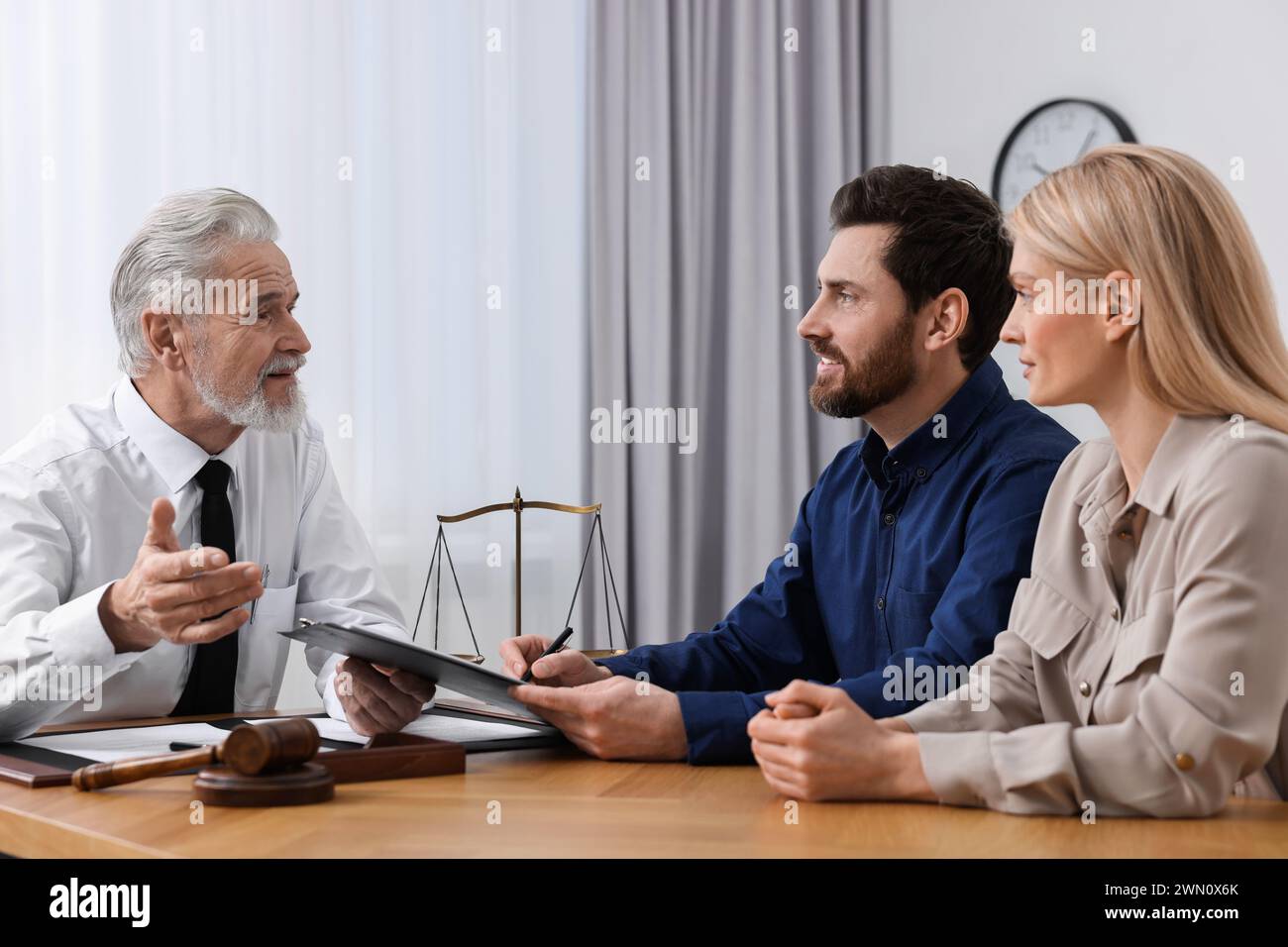 Happy couple signing document in lawyer's office Stock Photo - Alamy