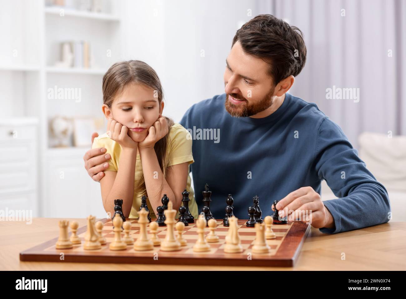 Father teaching his daughter to play chess at home Stock Photo - Alamy