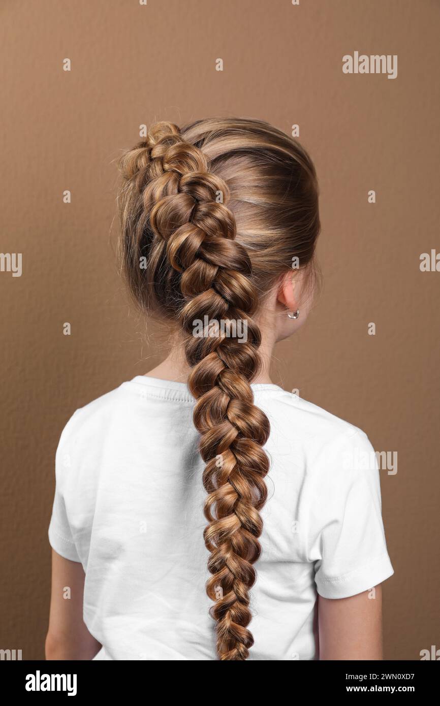 Little girl with braided hair on light brown background, back view ...