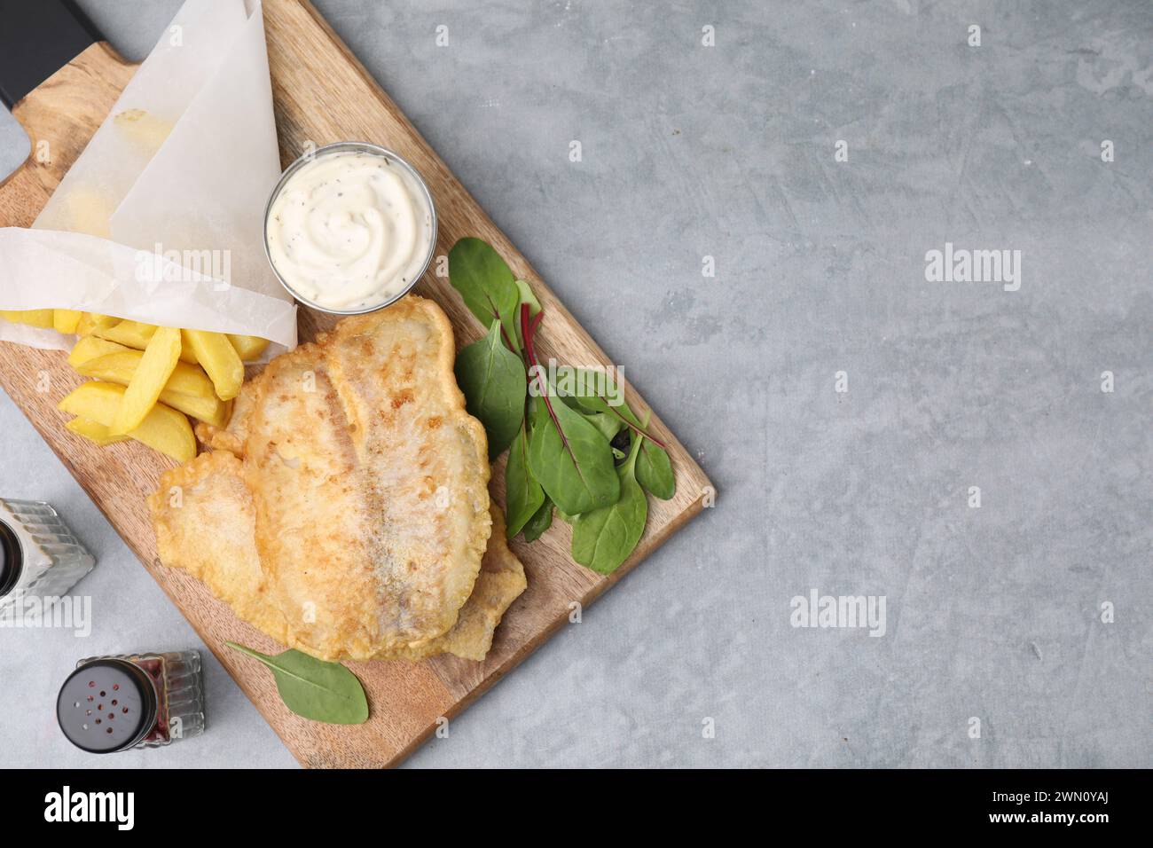 Delicious fish and chips with tasty sauce, mangold and spices on gray ...