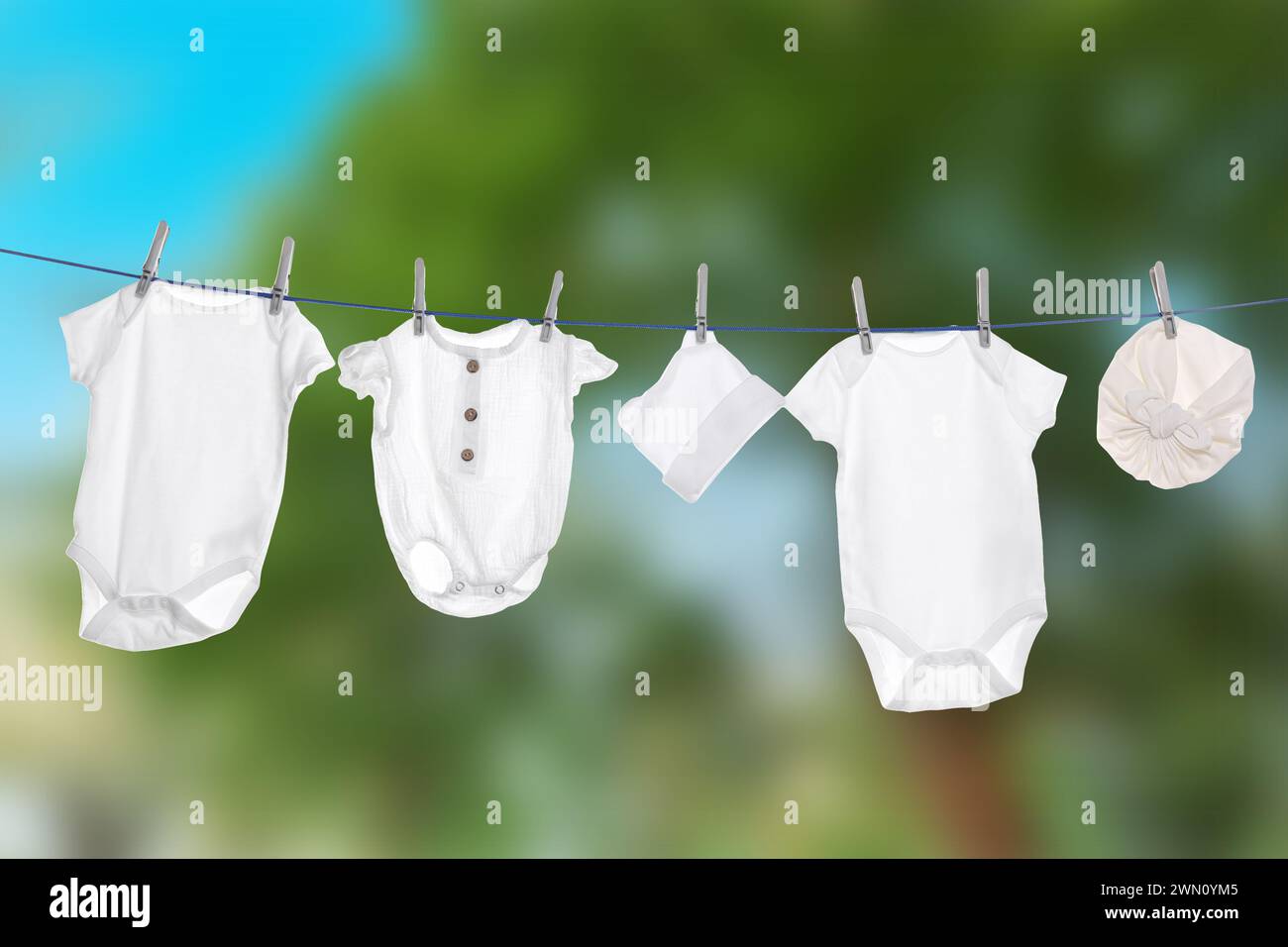 Different baby clothes drying on washing line outdoors Stock Photo - Alamy