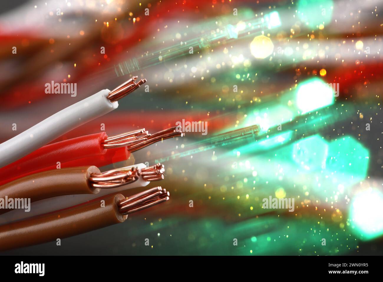 Colorful electrical wires against color background with blurred lights ...