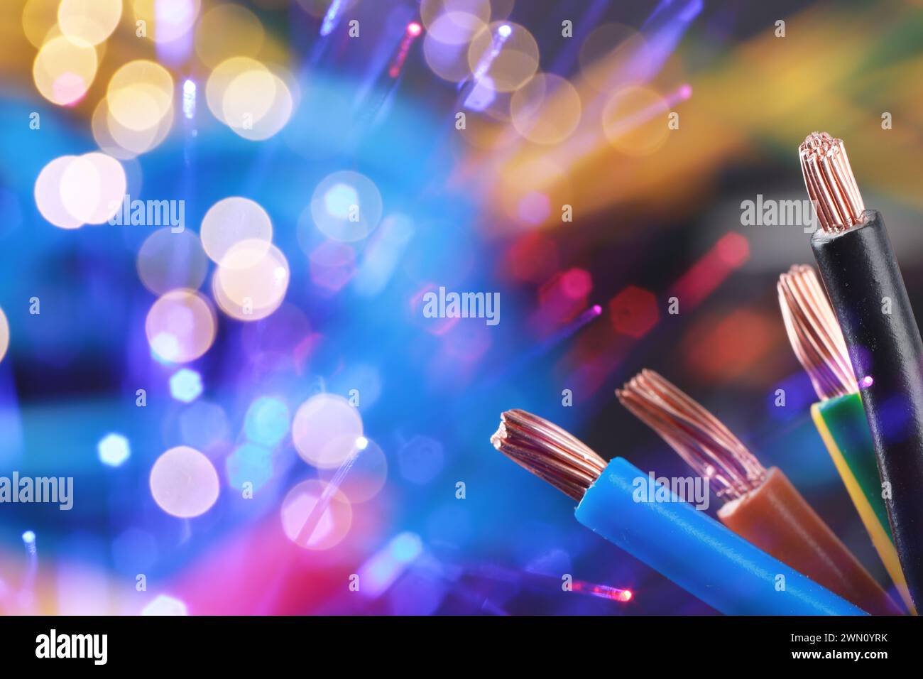 Colorful electrical wires against color background with blurred lights ...