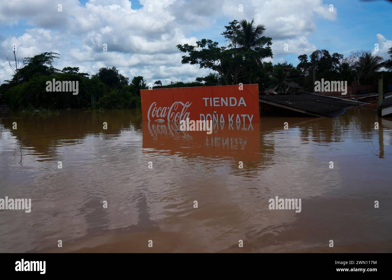 A food store billboard is submerged in floodwater in Cobija, Bolivia ...