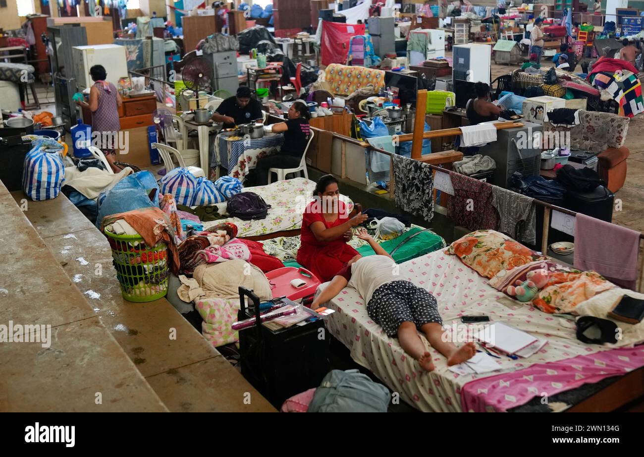 People rest in a shelter after their homes were flooded in Cobija ...