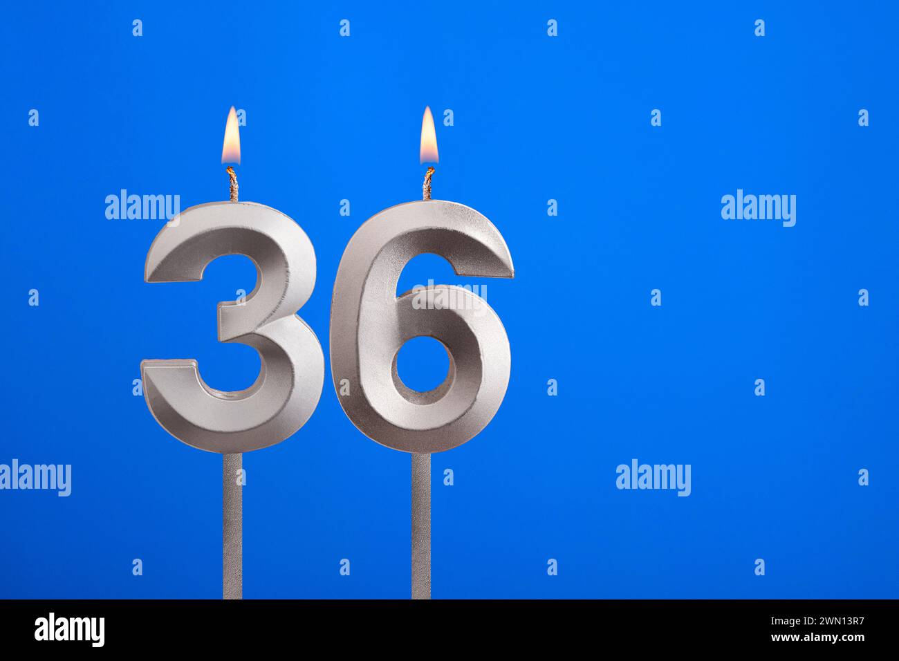 Birthday number 36 - Candle lit on blue background Stock Photo - Alamy