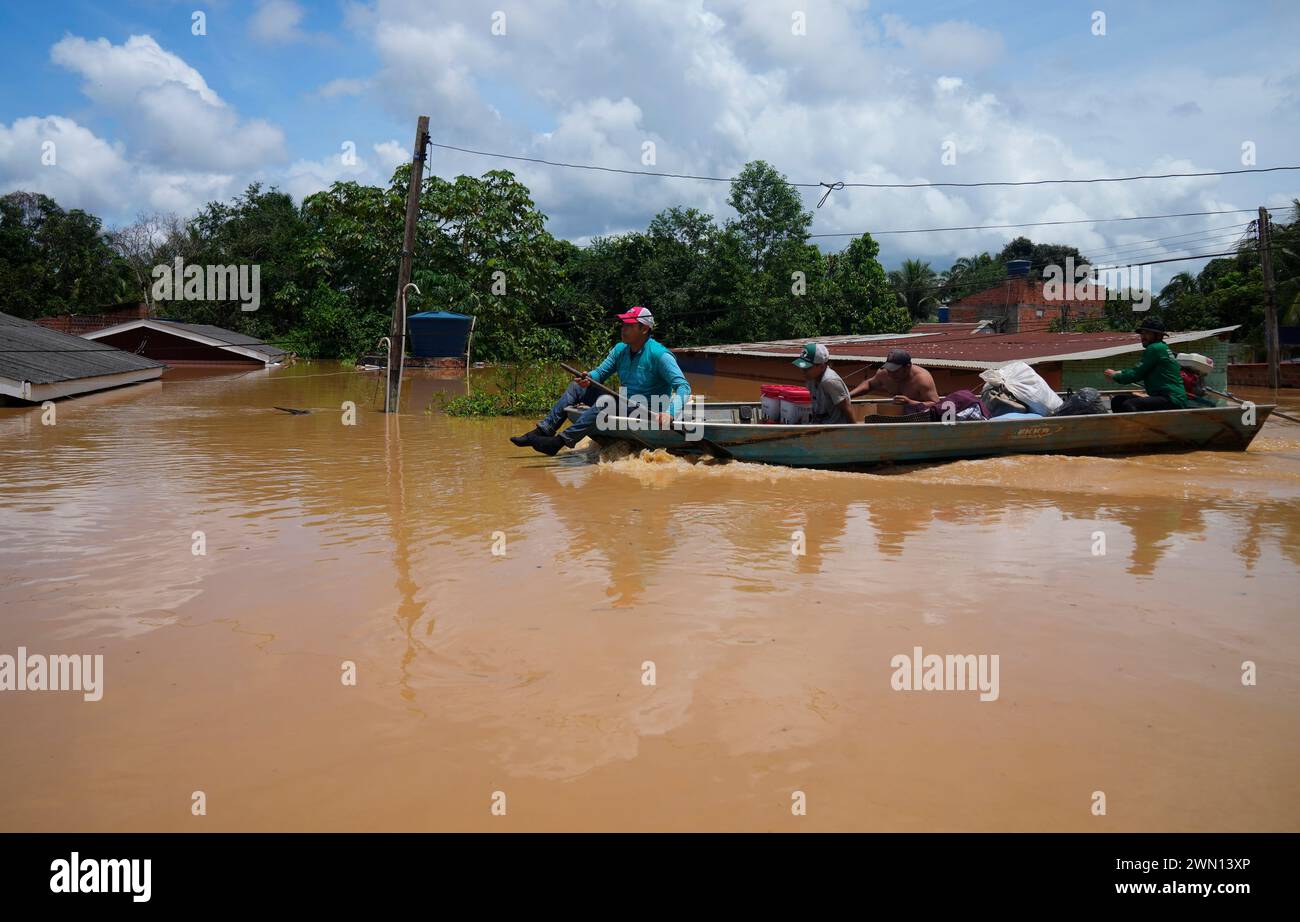 Residents navigate the flooded streets of Cobija, Bolivia, Wednesday ...